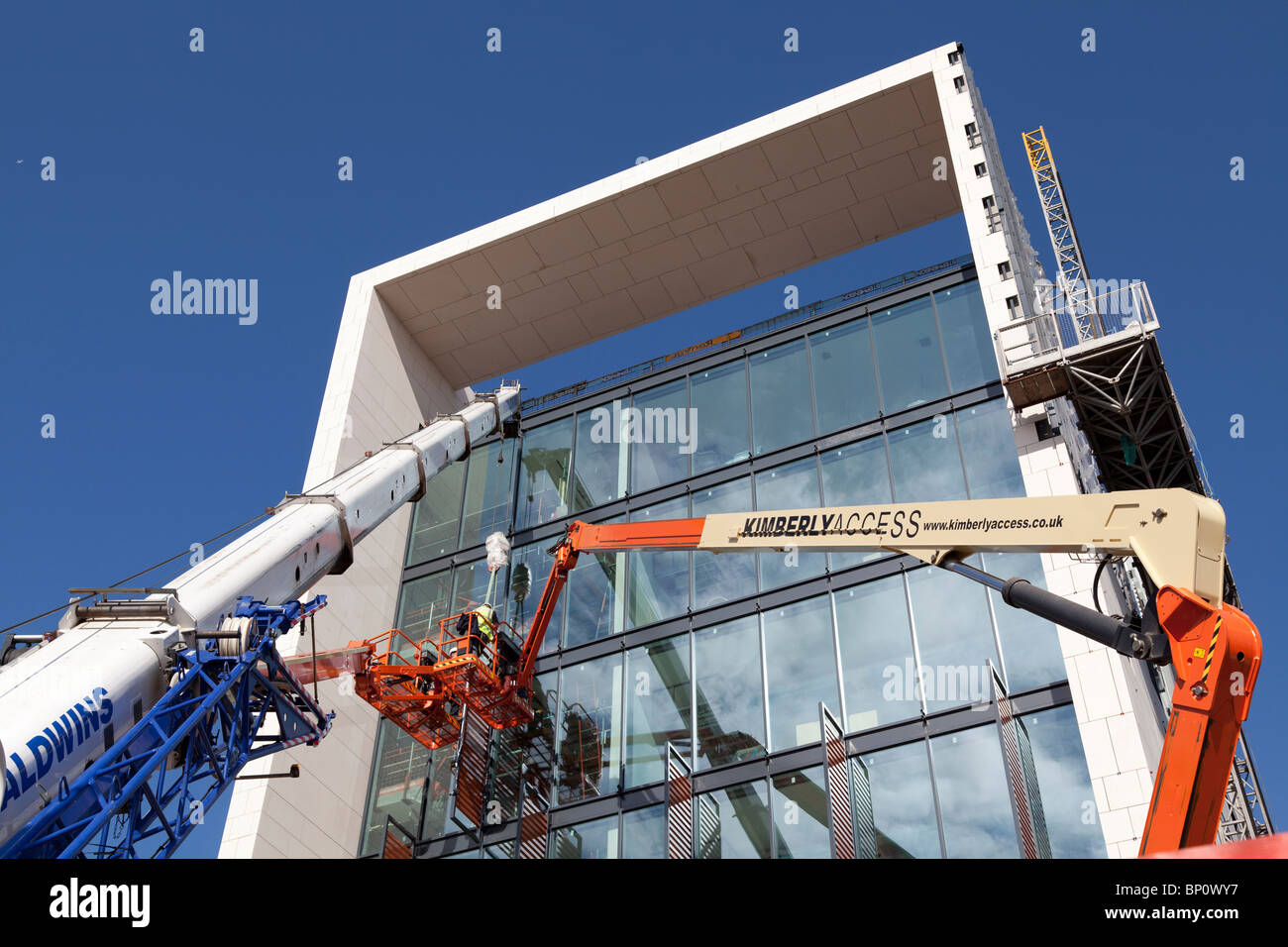 construction workers working at height to install cladding on Southern ...