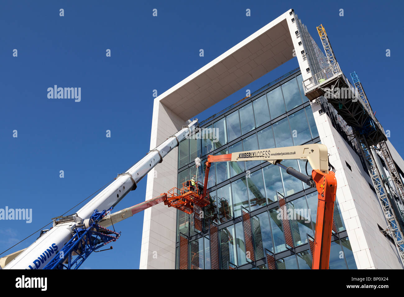 construction workers working at height to install cladding on Southern ...