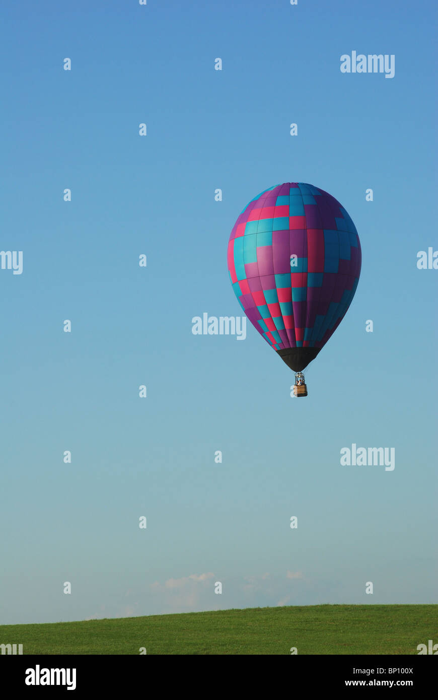 Single hot air balloon in flight against a blue sky Stock Photo - Alamy
