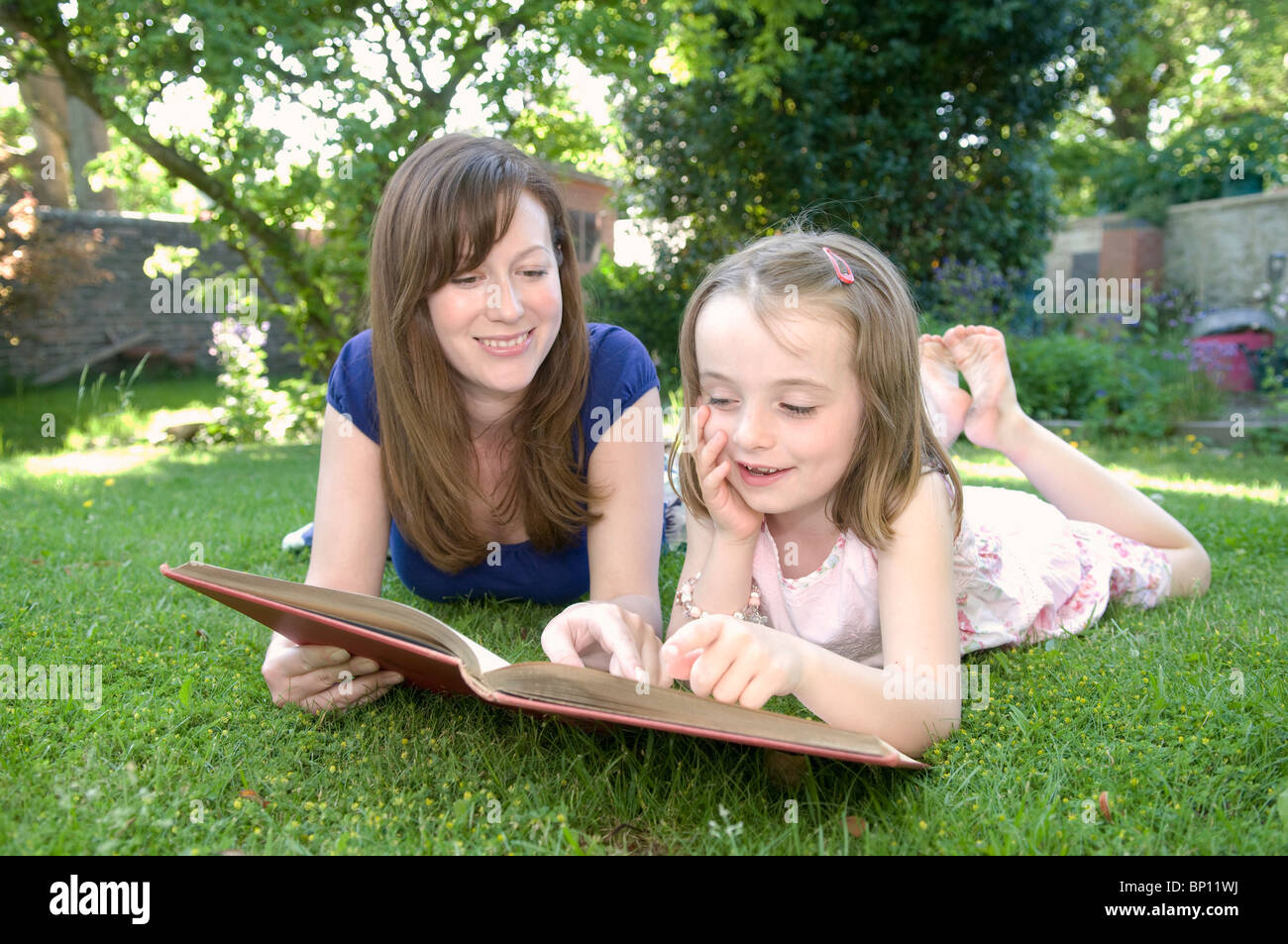 Woman and child read from book together Stock Photo - Alamy