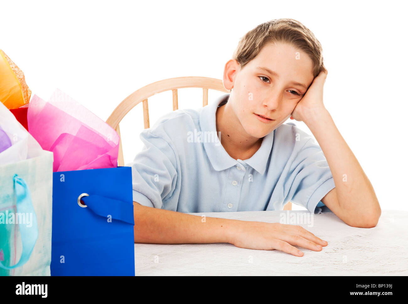 Little boy is bored waiting to open his birthday presents. White ...