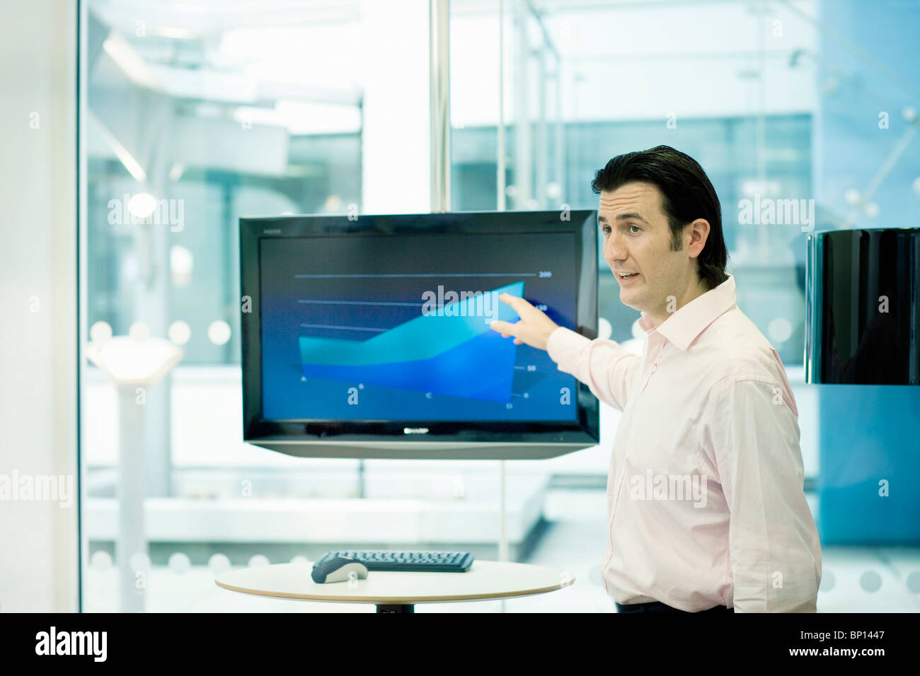 Businessman pointing at presentation Stock Photo - Alamy