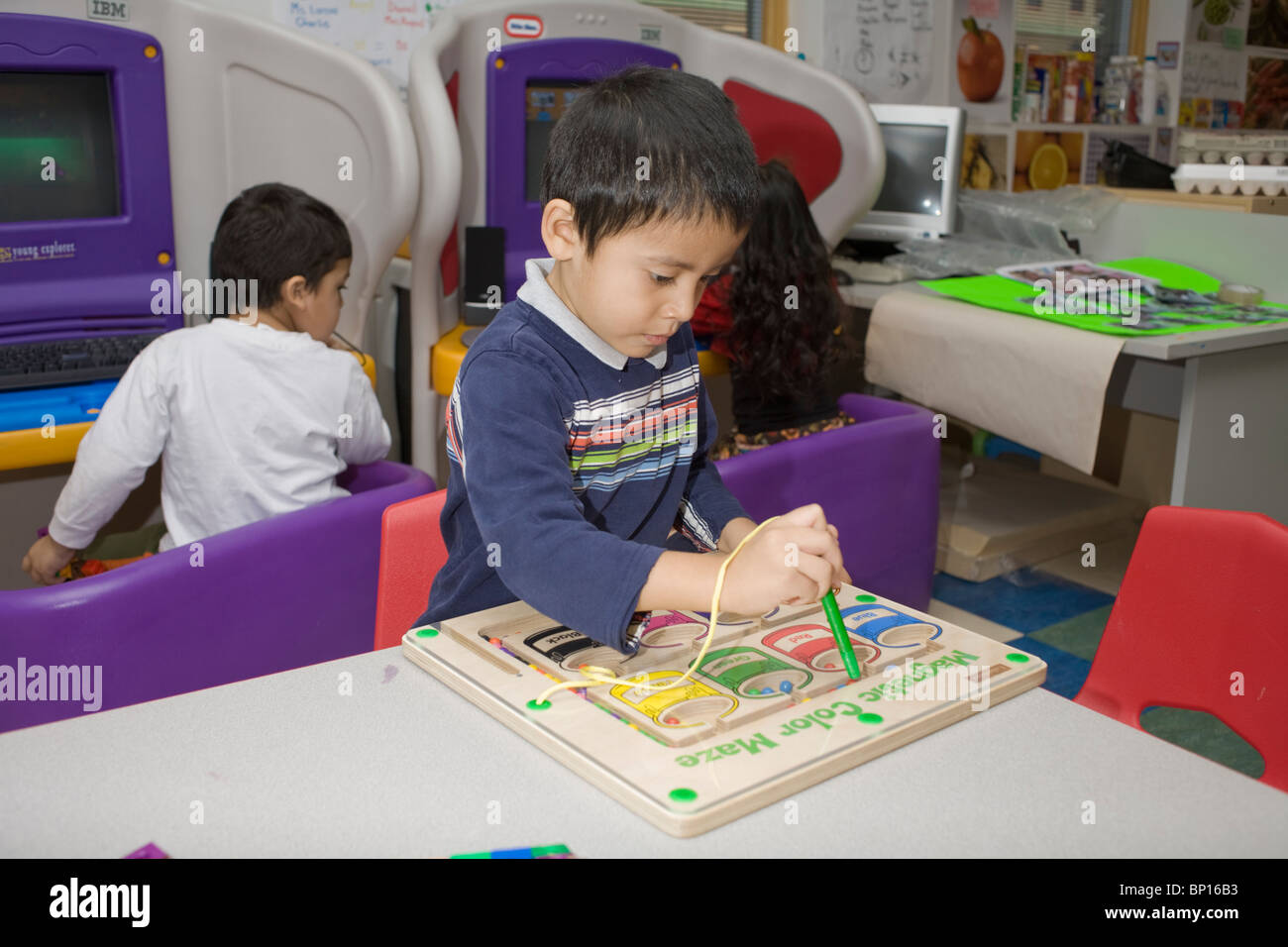 Preschool boy plating with a game at a table in the classroom Stock ...