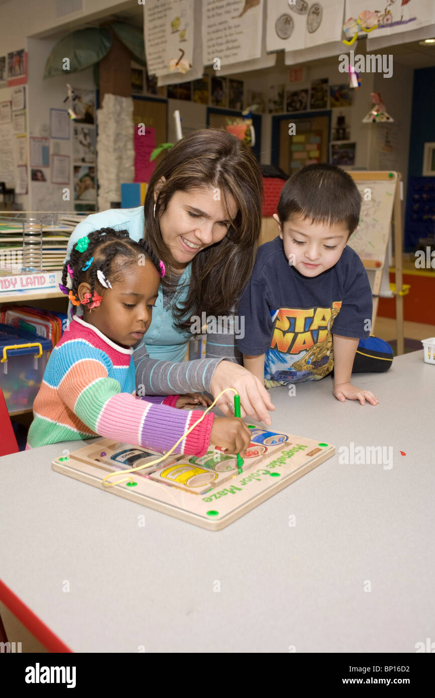 Preschool Teacher helping her students play a game Stock Photo - Alamy