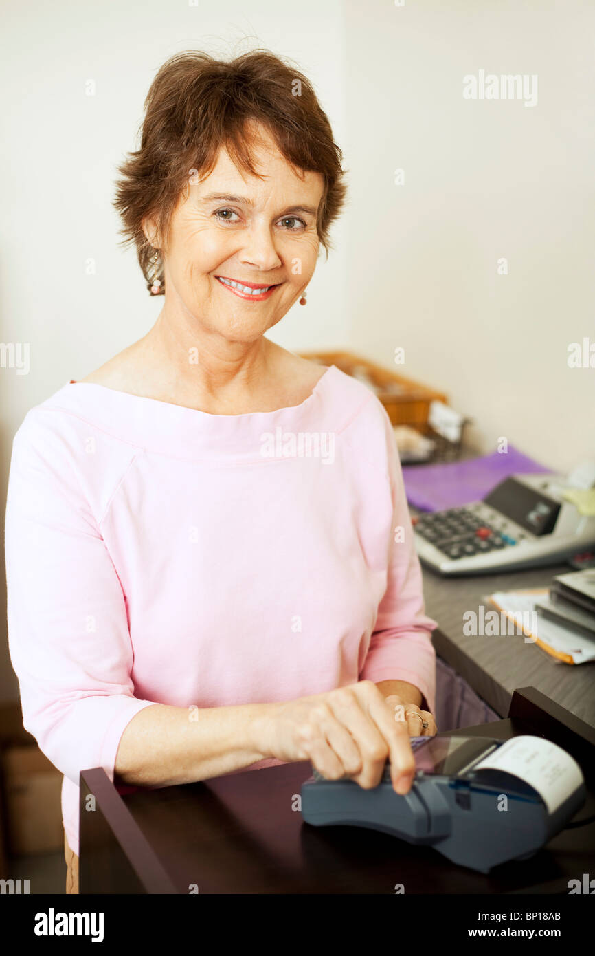 Friendly store clerk running a credit card through the scanner Stock ...