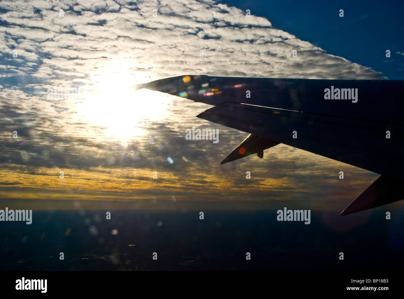 Airplane Flying below the Clouds at twilight Stock Photo - Alamy