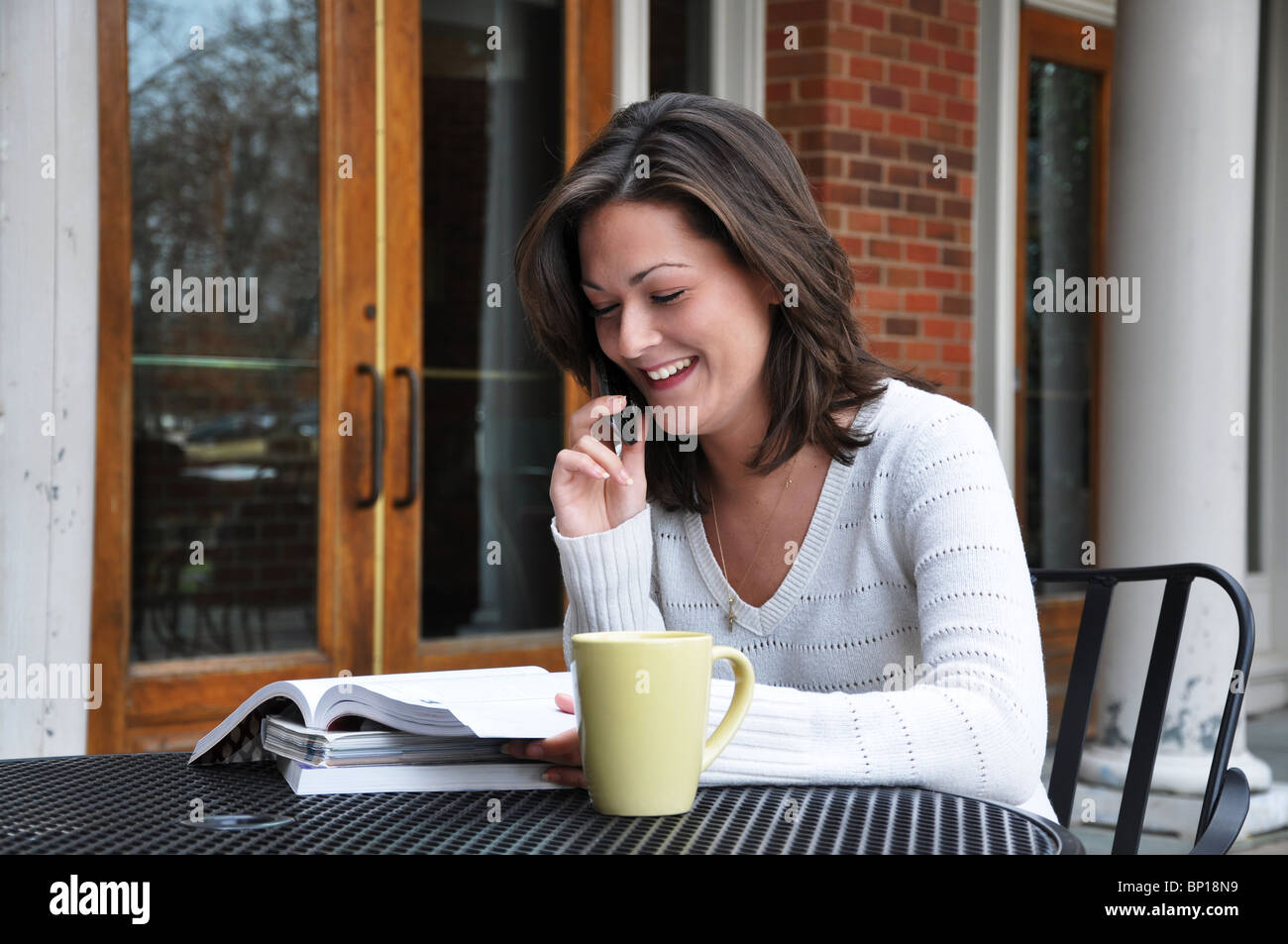 Female student studying while talking on cell phone Stock Photo - Alamy