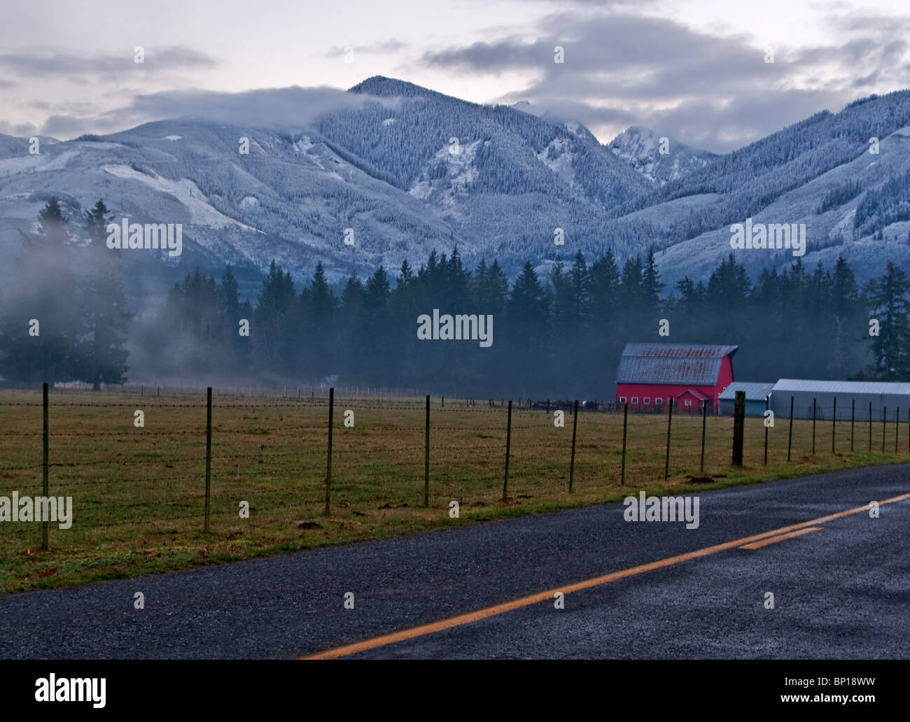 This winter country farm scene has a red barn in the background with a ...