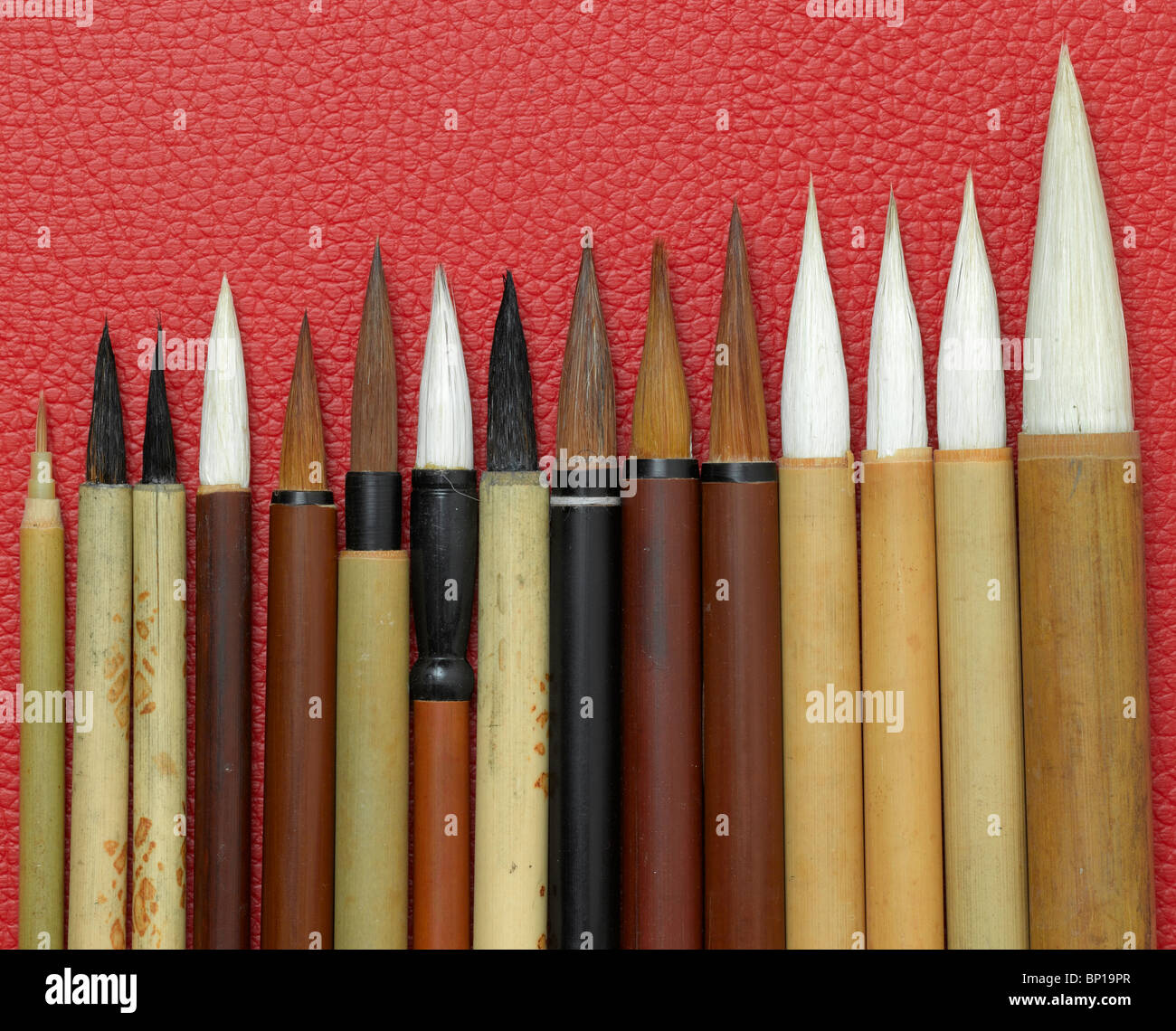 Set of old chinese brushes on red background Stock Photo - Alamy