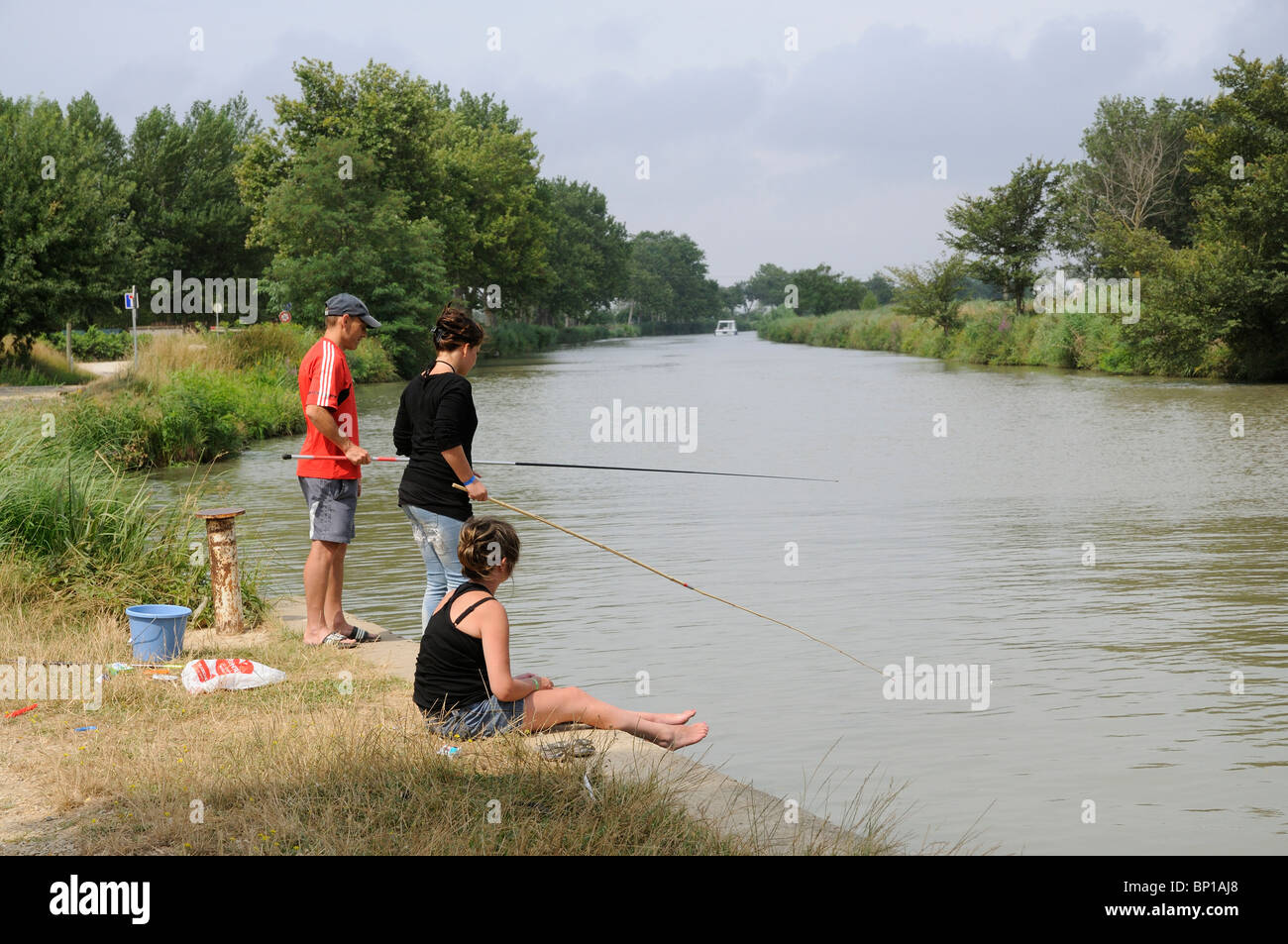 Youngsters fishing on the Canal du Midi at Portiranges near Beziers ...