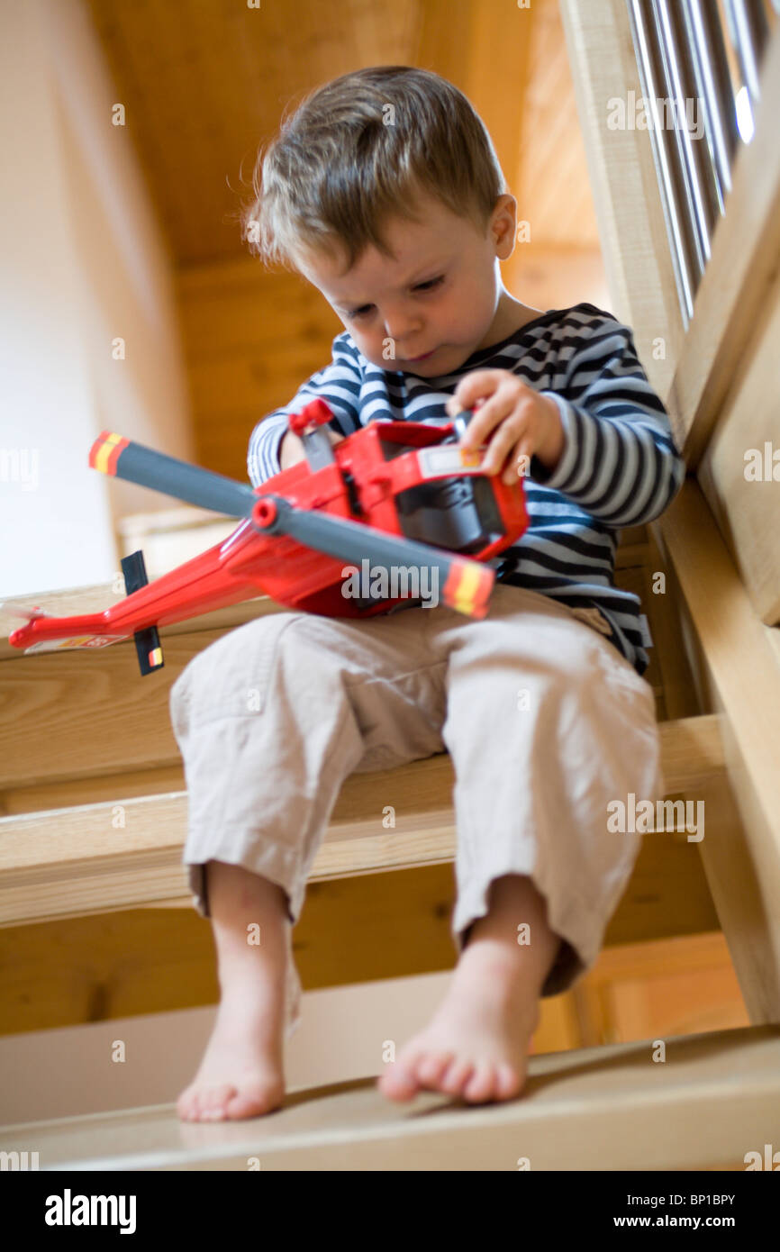 Little boy playing, sitting on stairs Stock Photo - Alamy