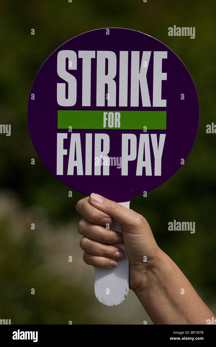 A striking Government worker holds a Strike for Fair Pay placard ...