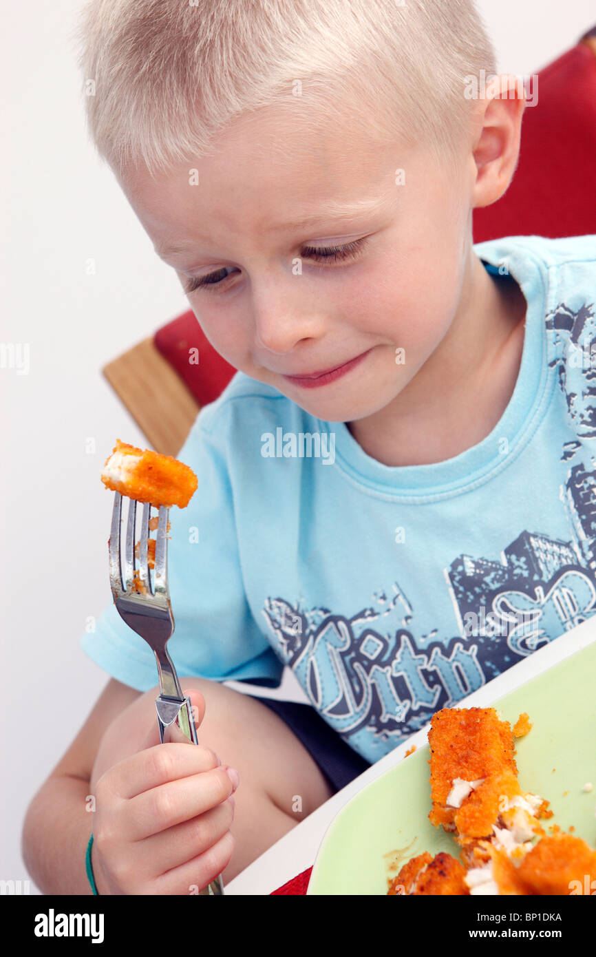 Little boy eating breaded fish Stock Photo - Alamy