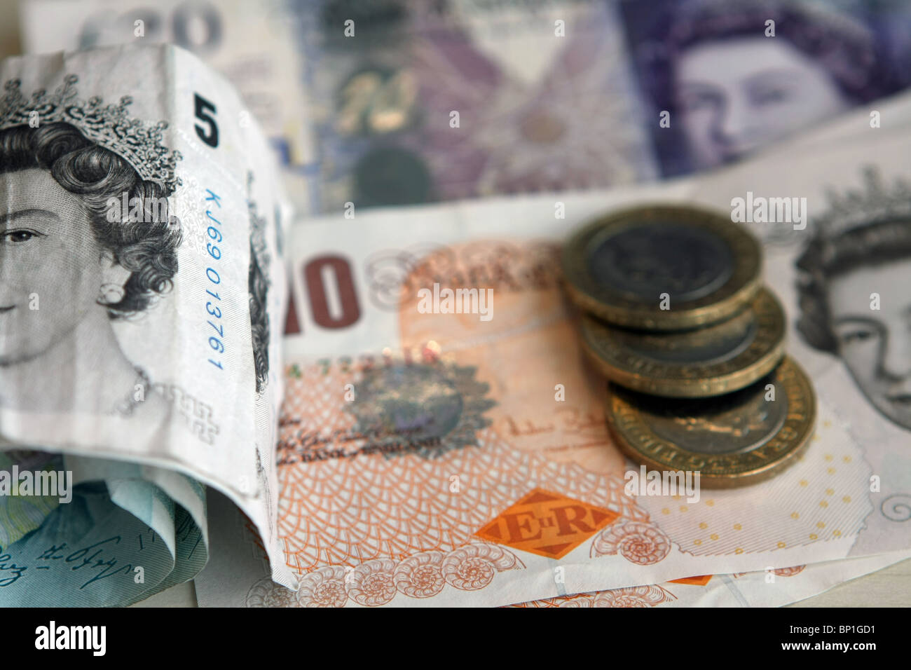 Folded £5 notes next to £2 coins on £20 and £10 notes Stock Photo - Alamy