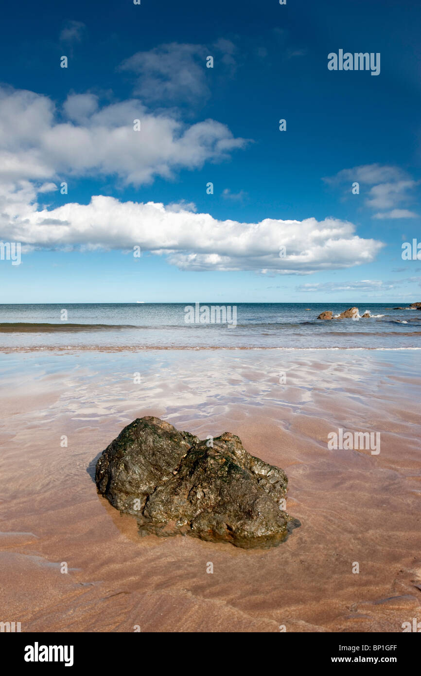 Northumberland, England; A Rock Sitting In Shallow Water At Low Newton ...