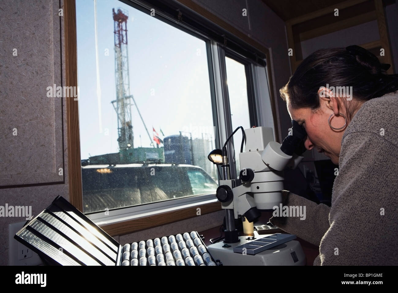 Edson, Alberta, Canada; Geologist Looking Into A Microscope At Samples ...