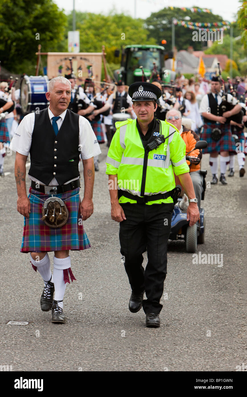 Pipe band member and policeman marching Stock Photo - Alamy