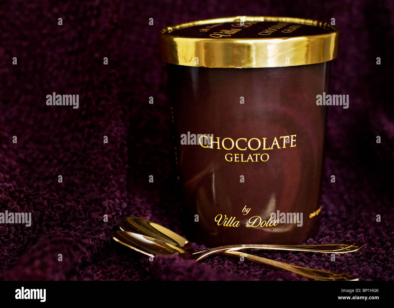 A fancy carton of chocolate gelato and two spoons are ready to be ...