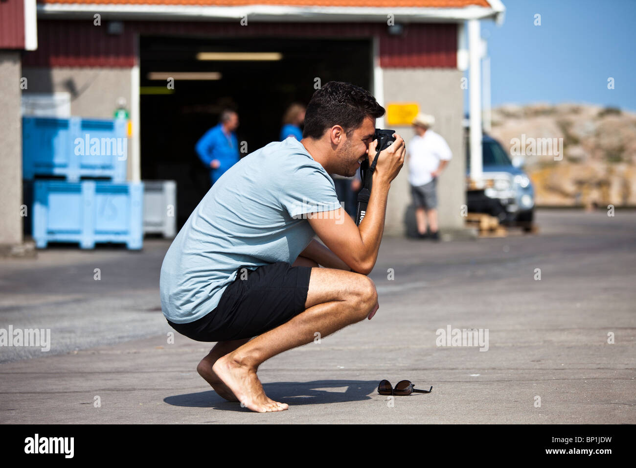 Man sitting down taking a pictures outdoors Stock Photo - Alamy