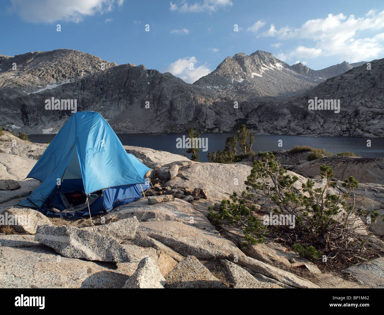Bright blue backpack tent perched high in the Sierra Nevada mountains ...