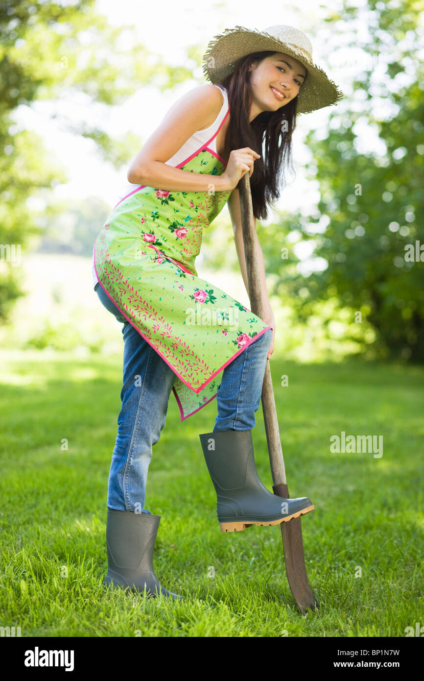 Young woman with foot on a spade Stock Photo - Alamy