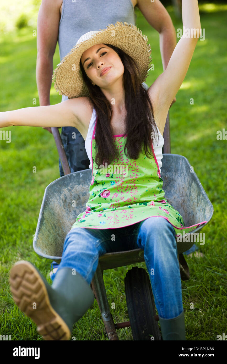 Young woman sitting in wheelbarrow Stock Photo - Alamy