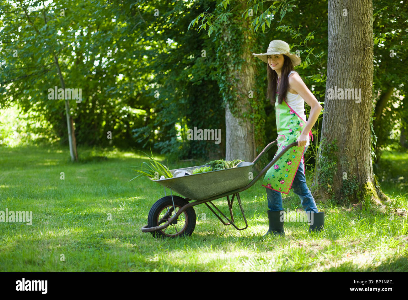 Young woman pushing wheelbarrow Stock Photo - Alamy