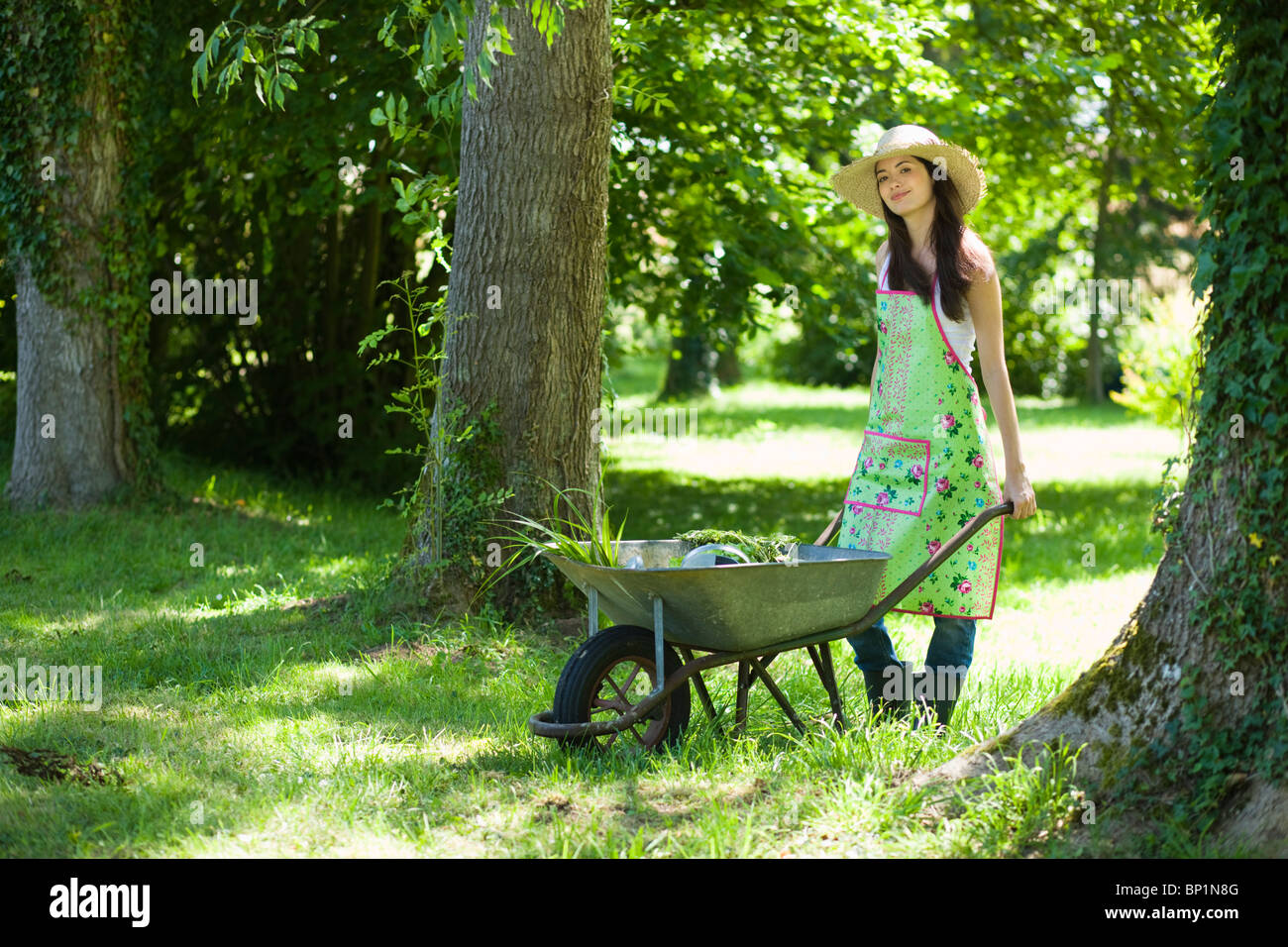 Young woman pushing wheelbarrow Stock Photo - Alamy