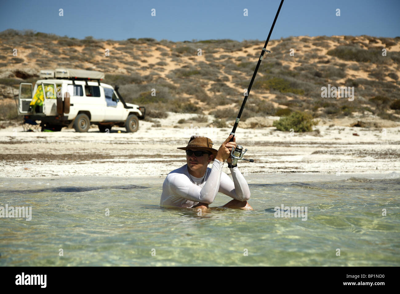 A young man sitting and fishing in the Indian Ocean, Goulet Bluff ...