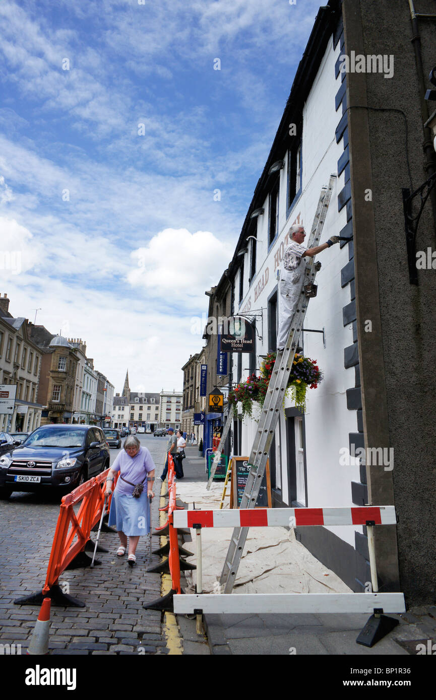 Health and safety - exterior decorators close the sidewalk and erect a ...