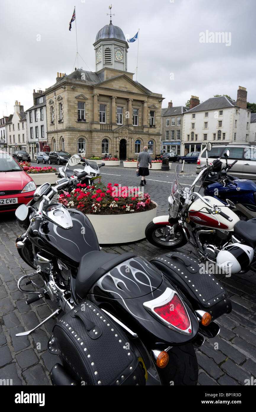 Kilted Scotsman walks past touring motorbikes in Kelso, Scotland, a top ...