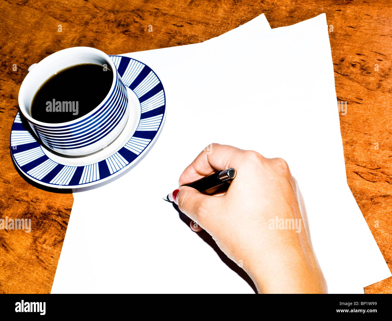 Woman writing on paper during coffee break Stock Photo - Alamy