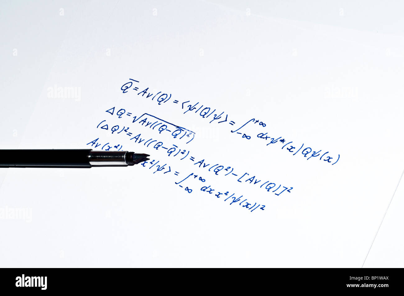 Maths or physics formula and black pen isolated on white background ...