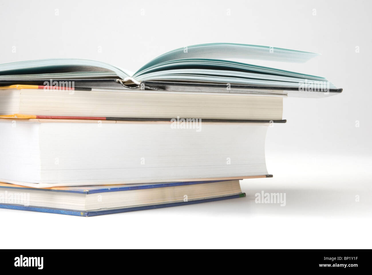 Three book and one opened on white background Stock Photo - Alamy