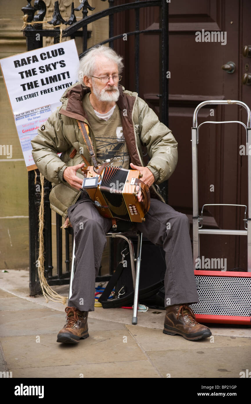 Busker playing accordion on the street during Brecon Jazz Festival 2010 ...