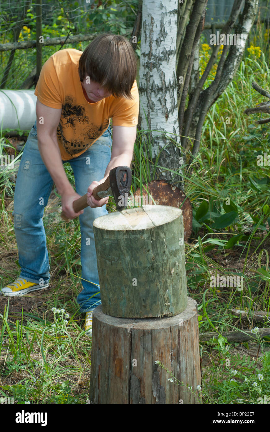 Young boy cutting the log Stock Photo - Alamy