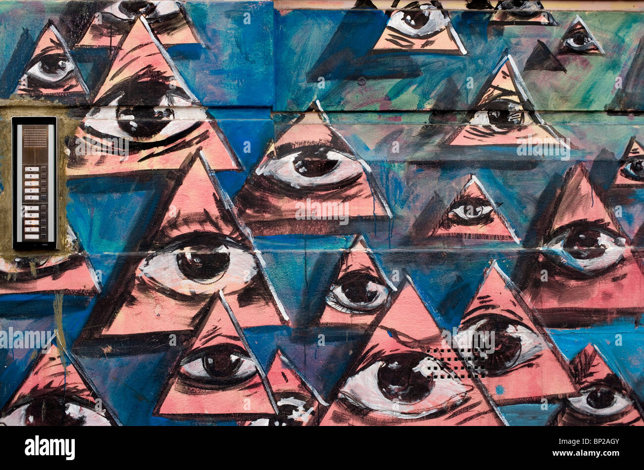 Wall of a block of flats painted with triangles containing open eyes ...