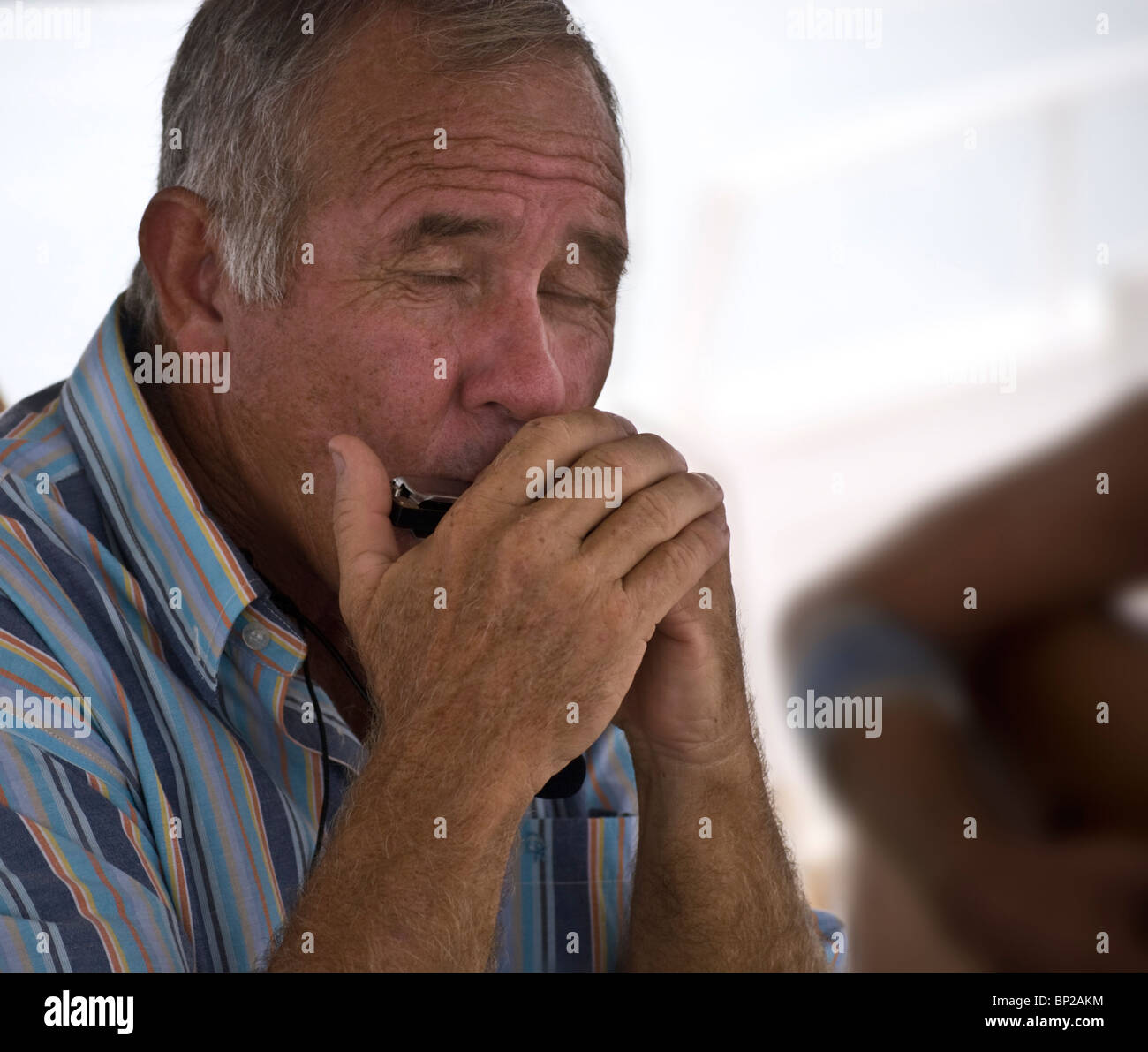 Male musician playing his harmonica, eyes shut Stock Photo - Alamy
