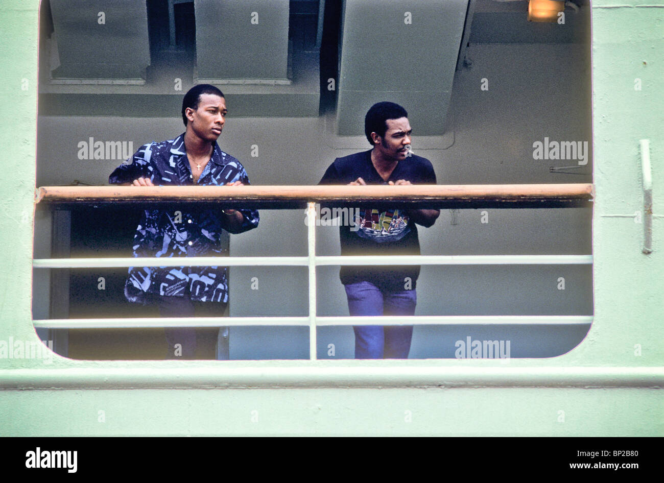Two cruise boat crew members watch ship docking Stock Photo - Alamy