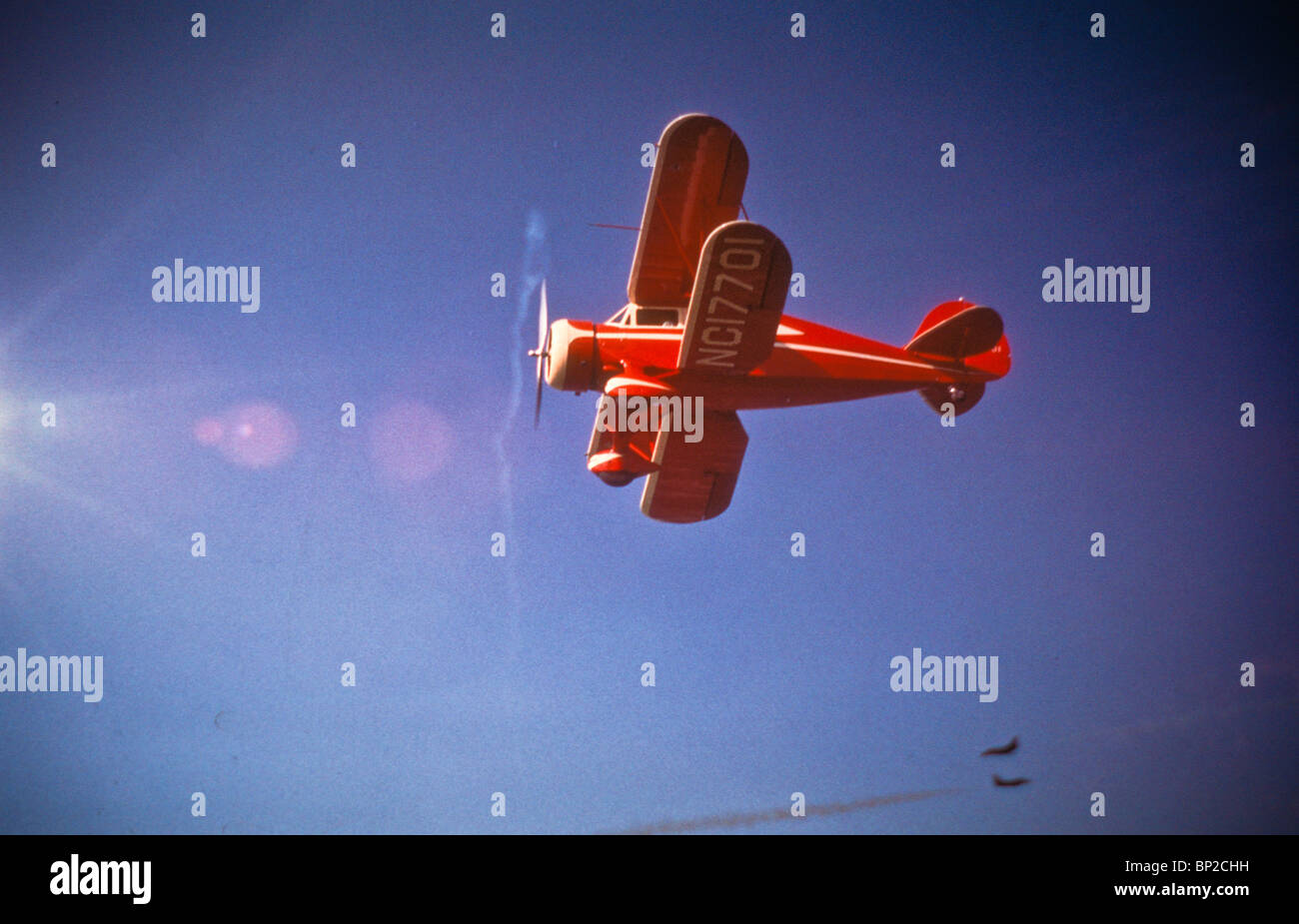 Red biplane performs at airshow Stock Photo - Alamy