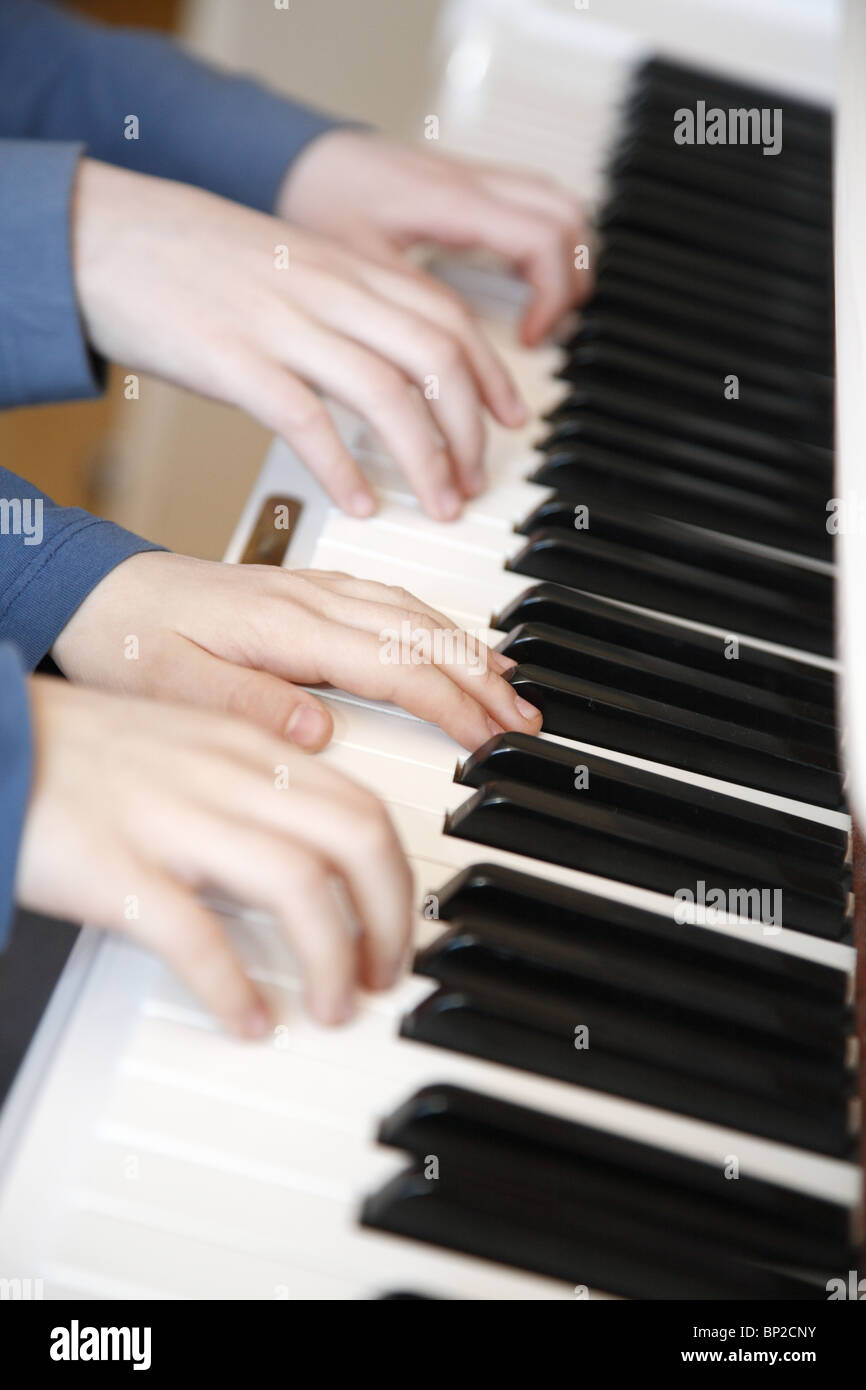 Four girls' hands on a piano keyboard Stock Photo - Alamy