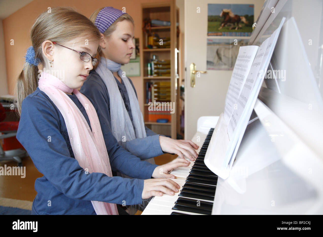 Two young girls playing piano together Stock Photo - Alamy