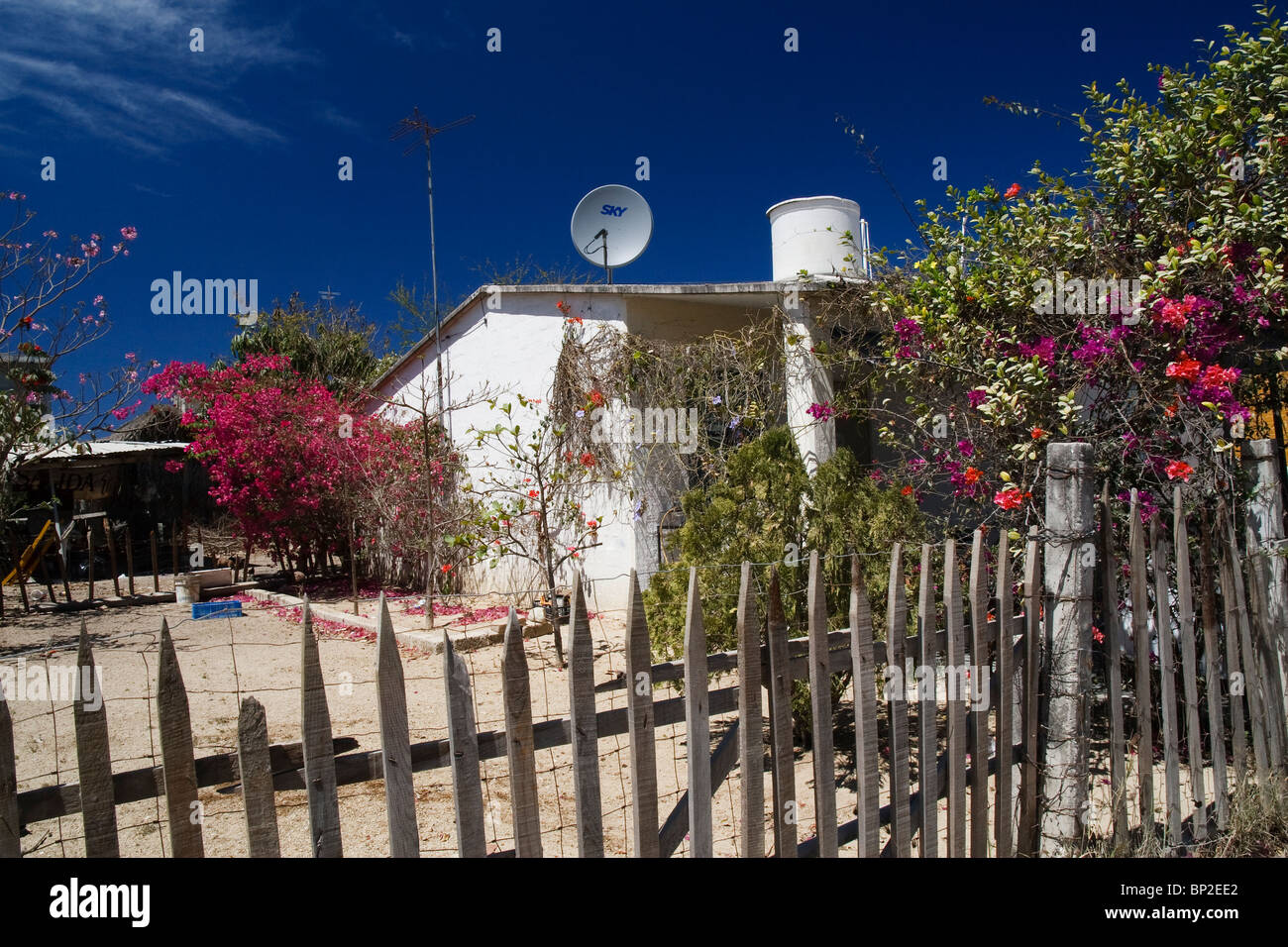 Side view of a modest house with a TV satellite dish on the roof in ...