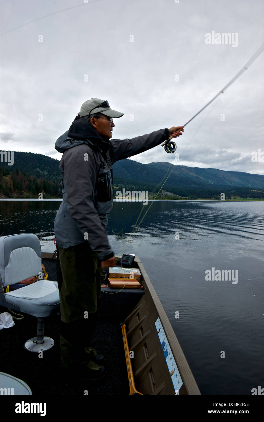 Sport fisherman fly casting with fishing rod and hand in double haul ...