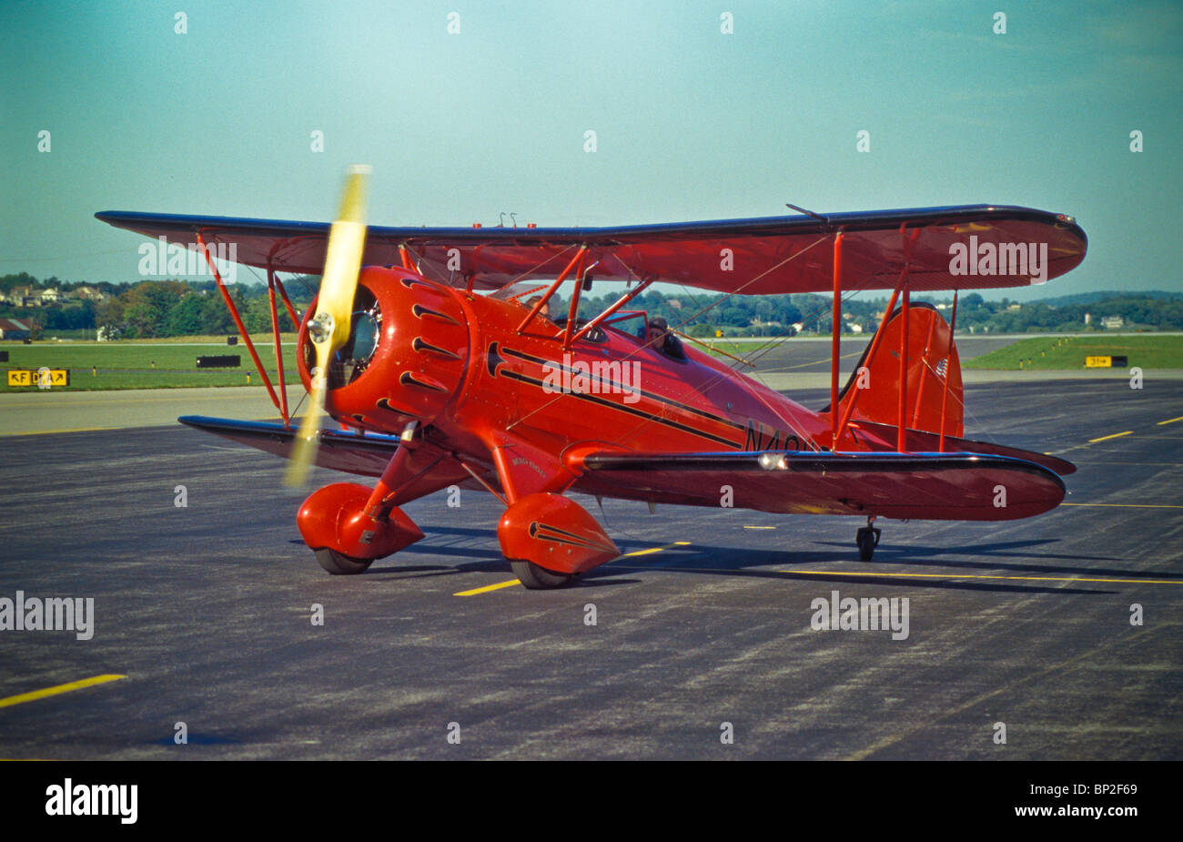 Antique red biplane revs engine Stock Photo - Alamy