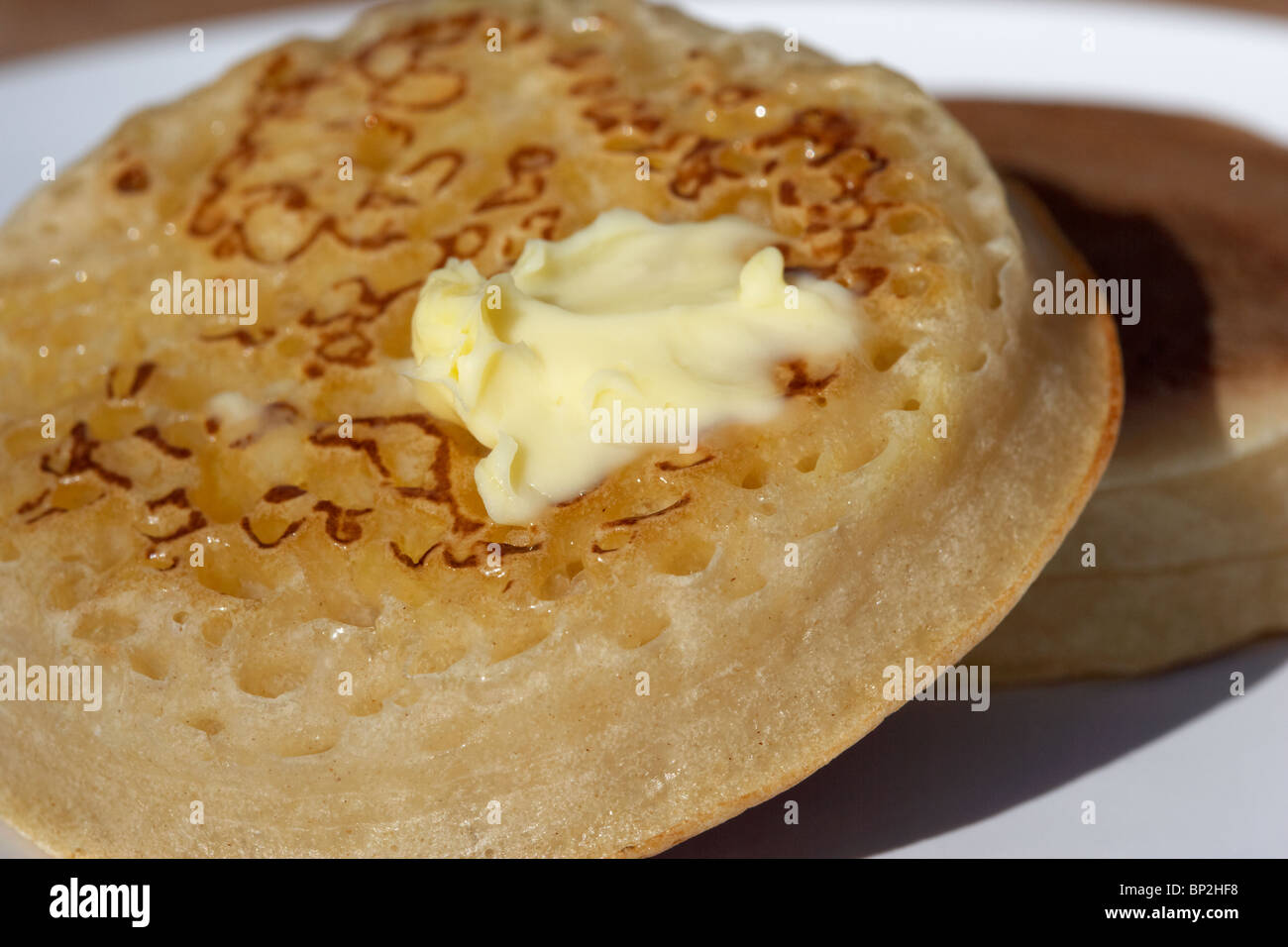 knob of butter melting on a traditional british crumpet Stock Photo - Alamy