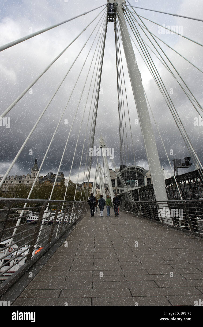 a london city suspension bridge over the thames in a rain shower Stock ...