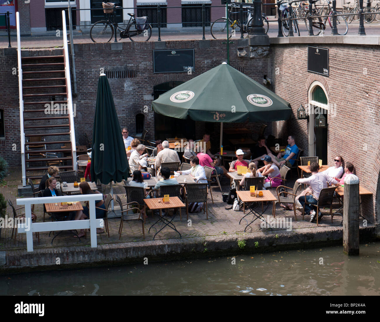 Busy outdoor summer cafe beside canal Oudegracht in central Utrecht in ...