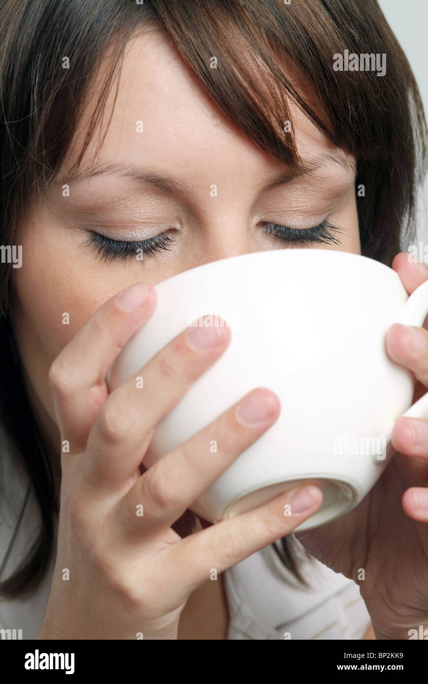 Young woman drinking from a cup Stock Photo - Alamy