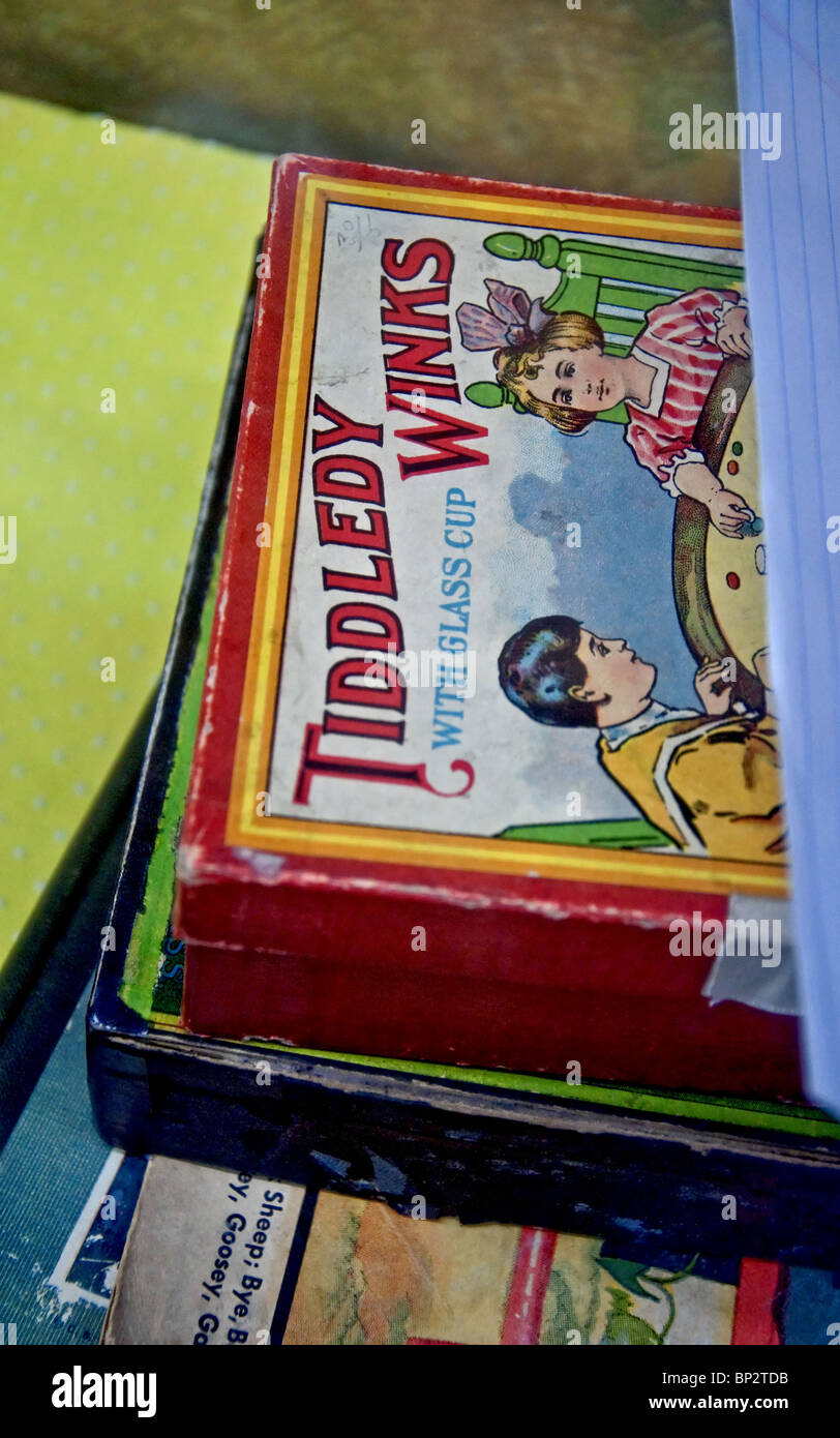 This vertical image is a stack of vintage games with tiddly winks being ...